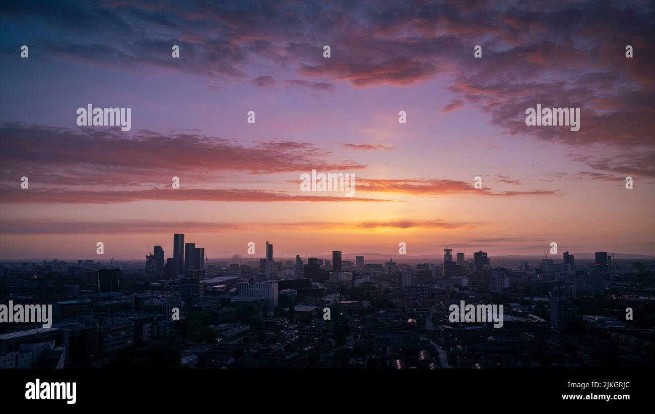 An aerial view of Manchester skyline against colorful sunset sky ...