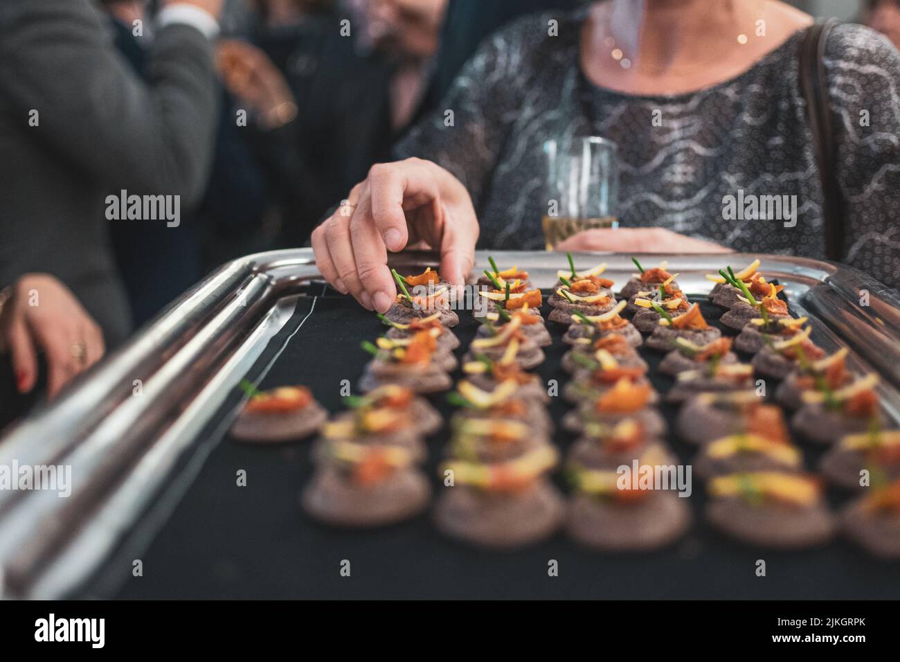 The waiter serving snacks to the guests Stock Photo - Alamy