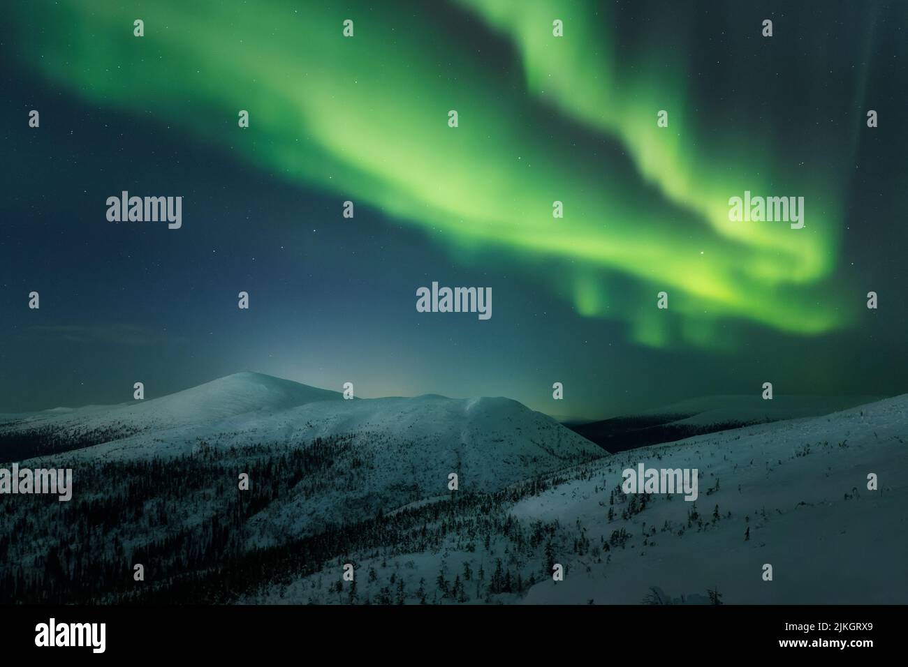 A snow-covered field under the beautiful Aurora Borealis sky Stock ...