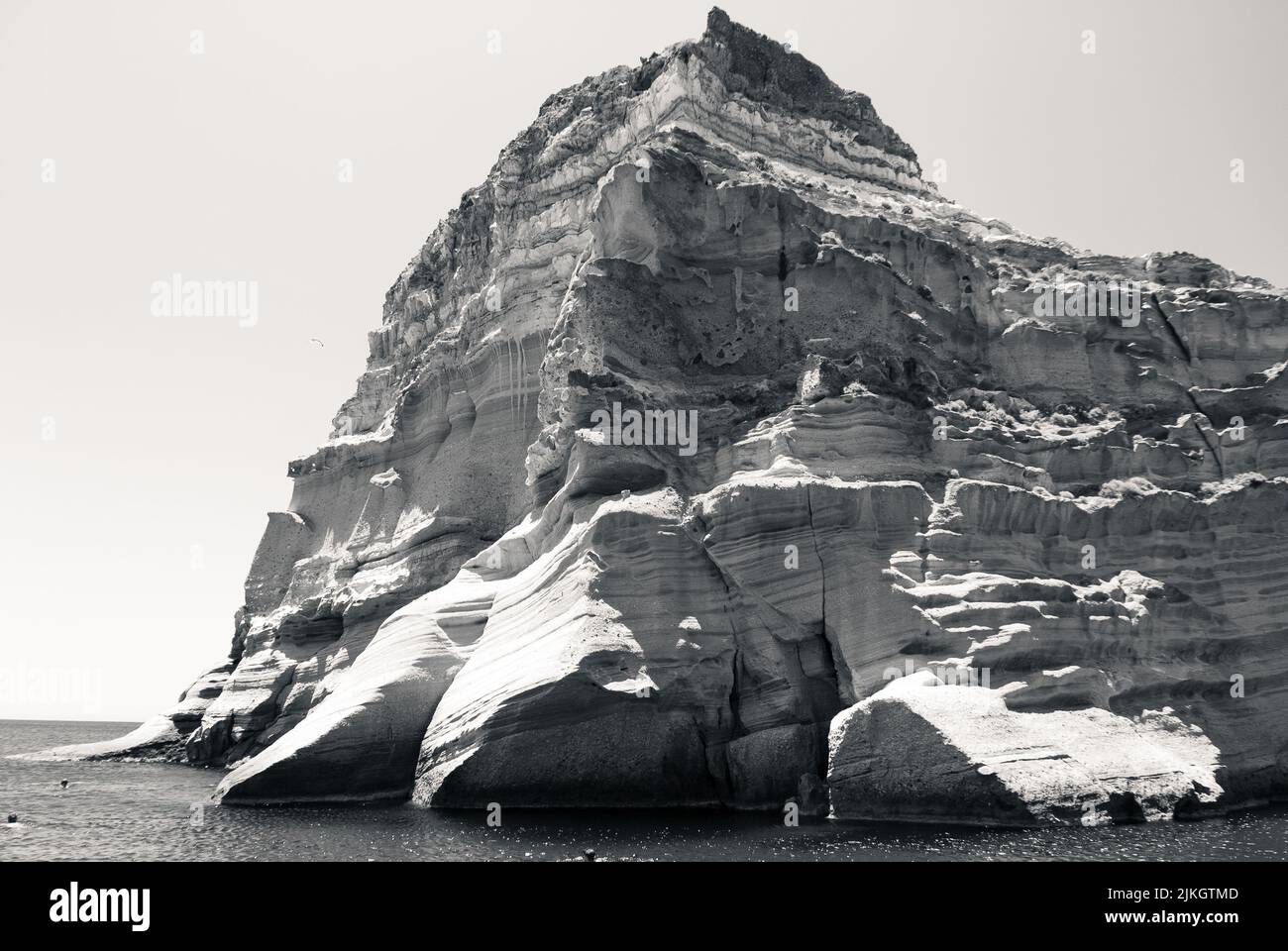 A grayscale shot of a huge cliff in Oia, Santorini, Greece Stock Photo ...