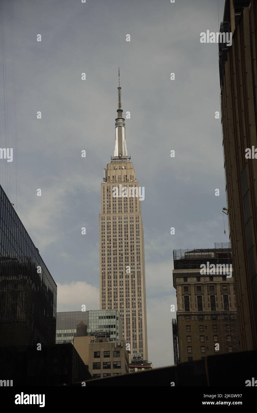 A low angle shot of the Empire State Building against a cloudy sky in ...