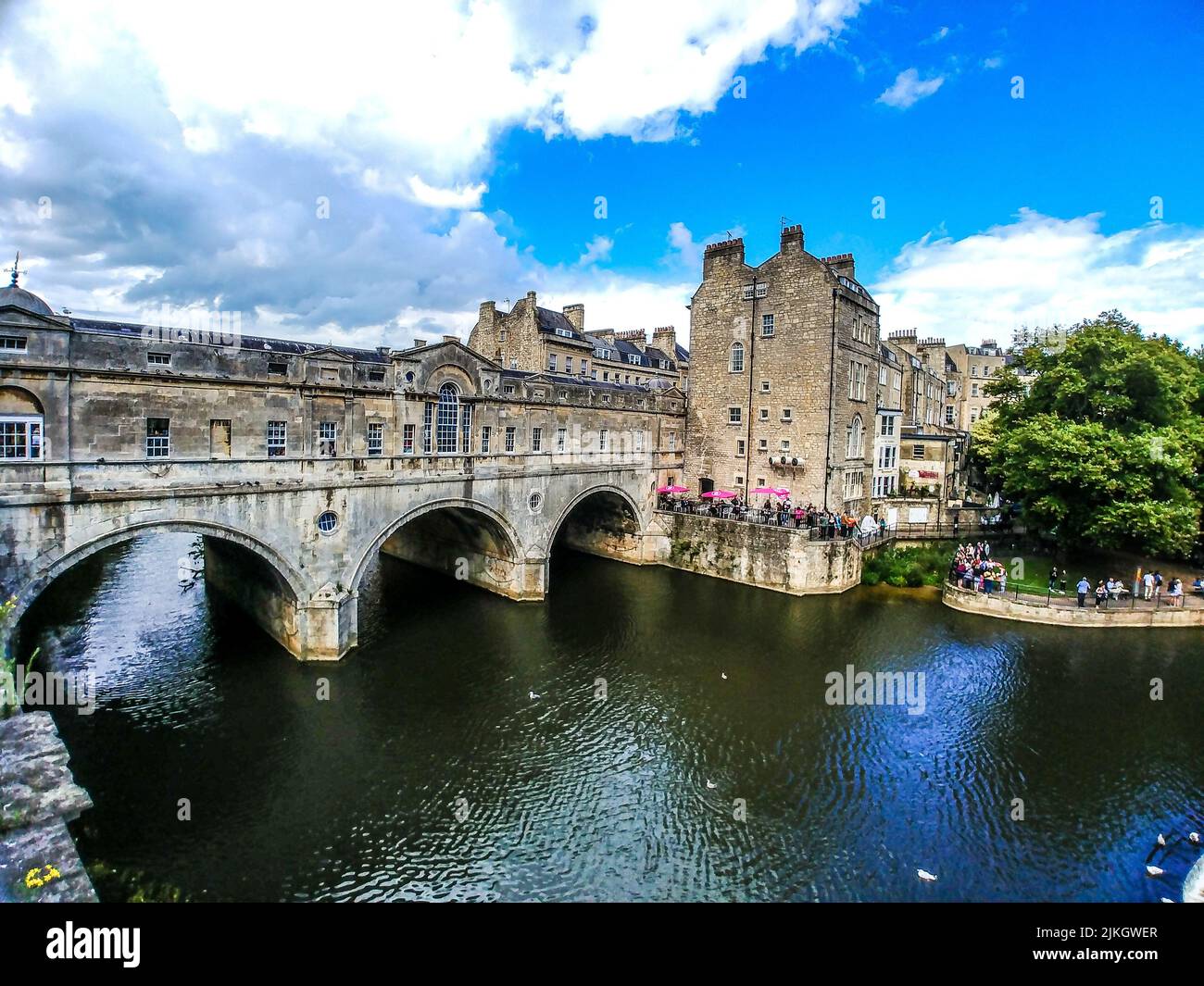 A view of the river and Pulteney Bridge over it surrounded by beautiful ...