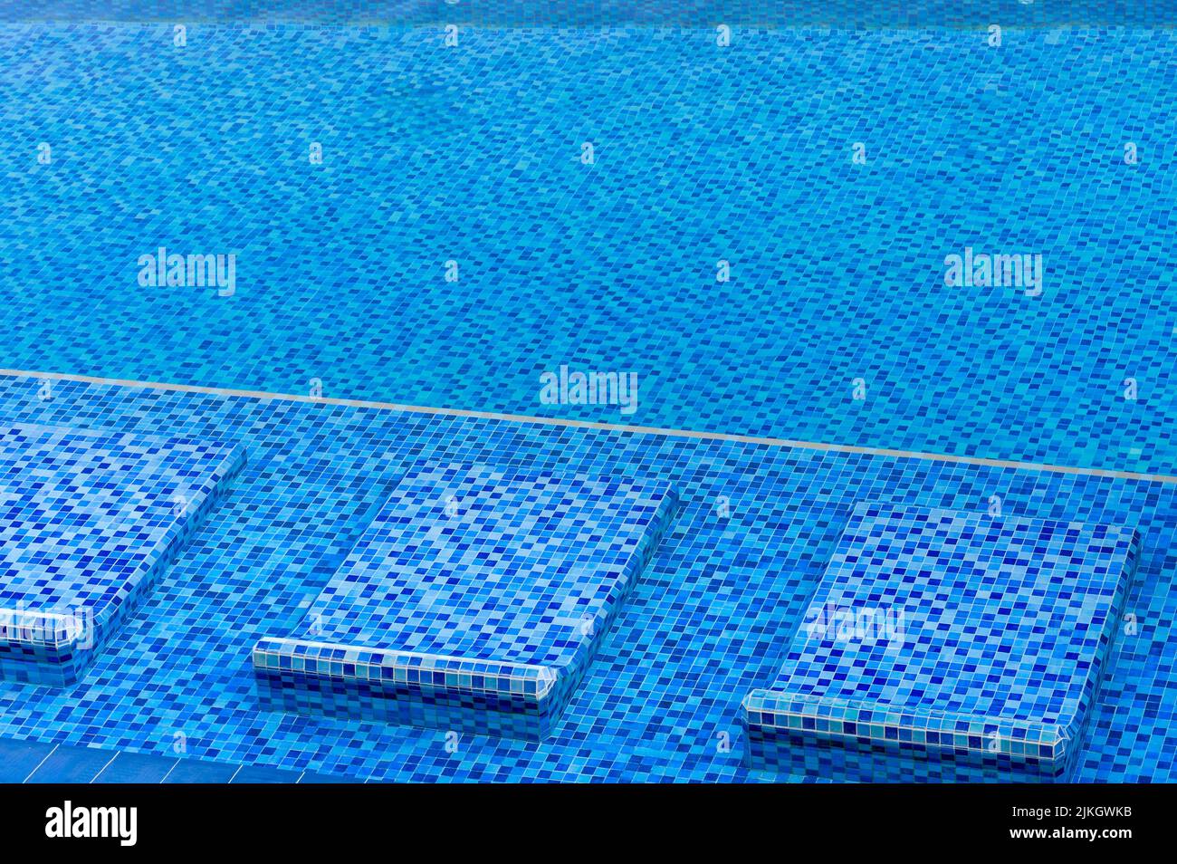 Summer and top view of a pool concrete lounge chairs Stock Photo - Alamy