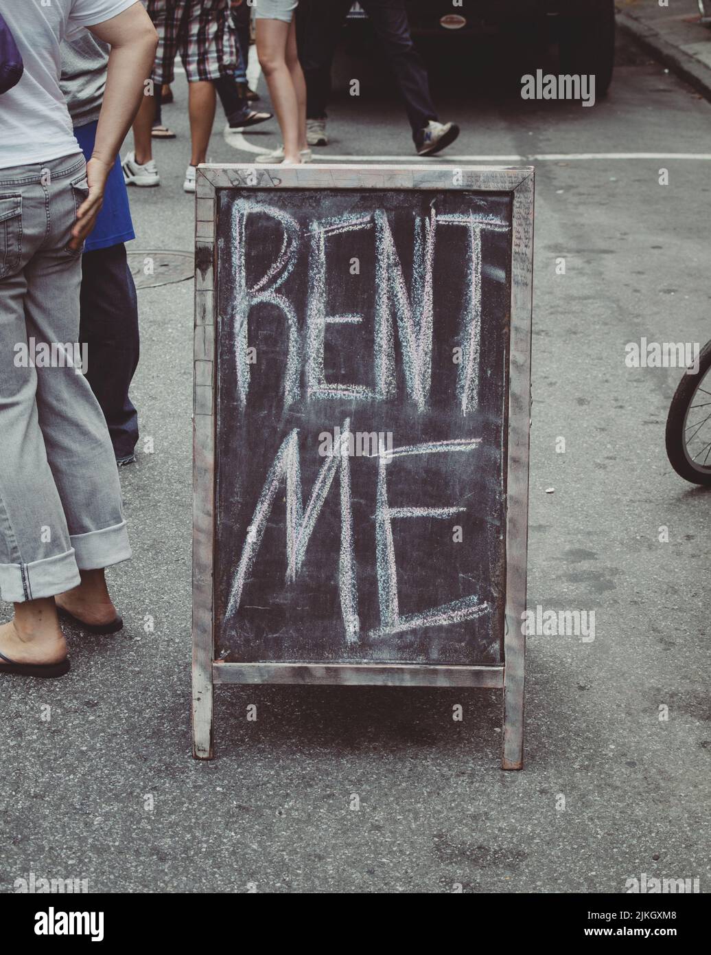 A vertical shot of a blackboard with a RENT ME message written with ...