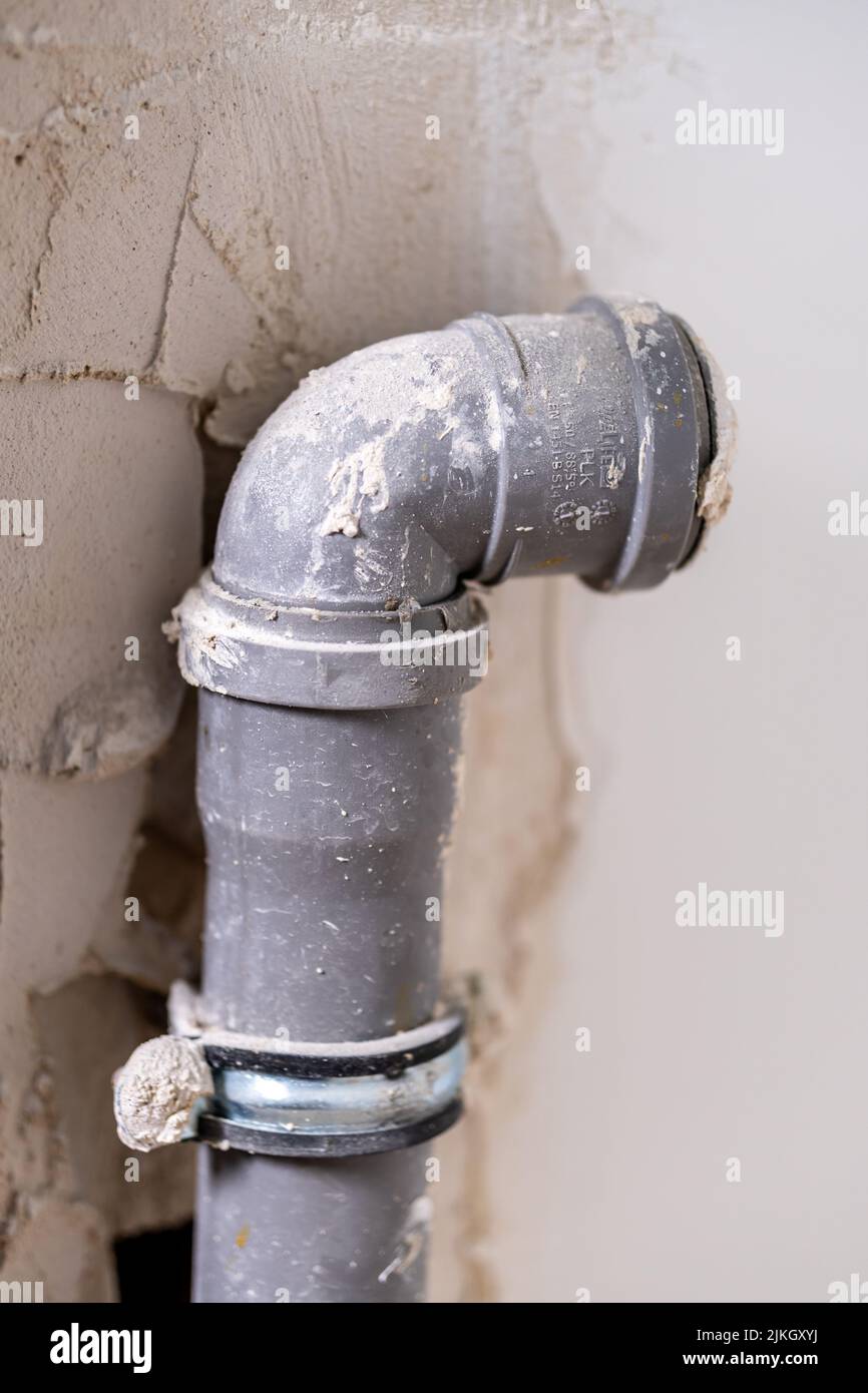 A grey plastic water pipe attached to a wall Stock Photo - Alamy