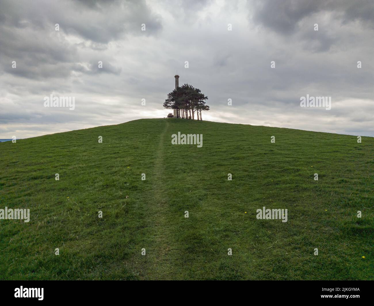 The War Memorial in Montgomery Wales with a bright sun behind the trees ...