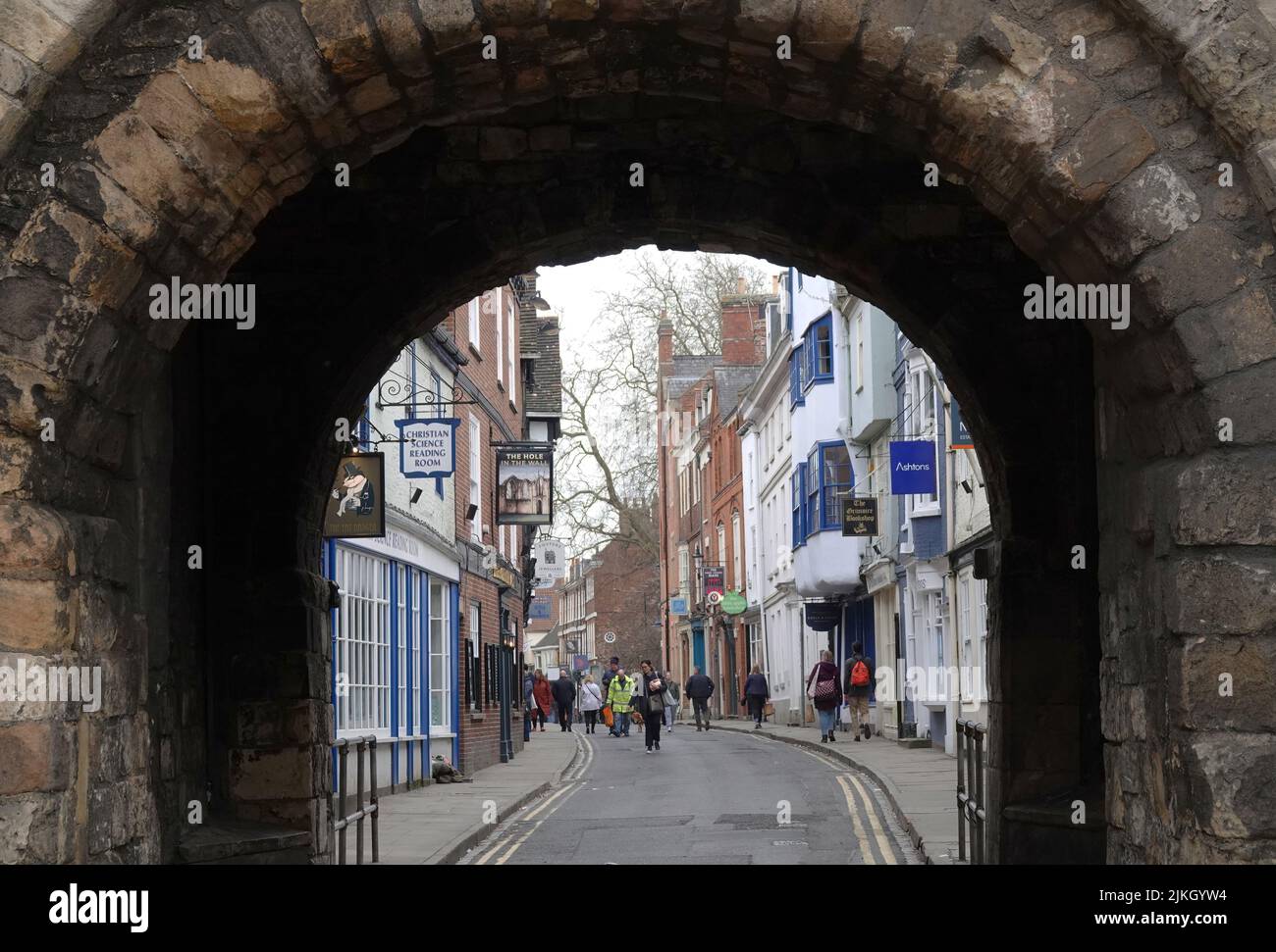 A group of people walking on the street through the archway of Bootham ...