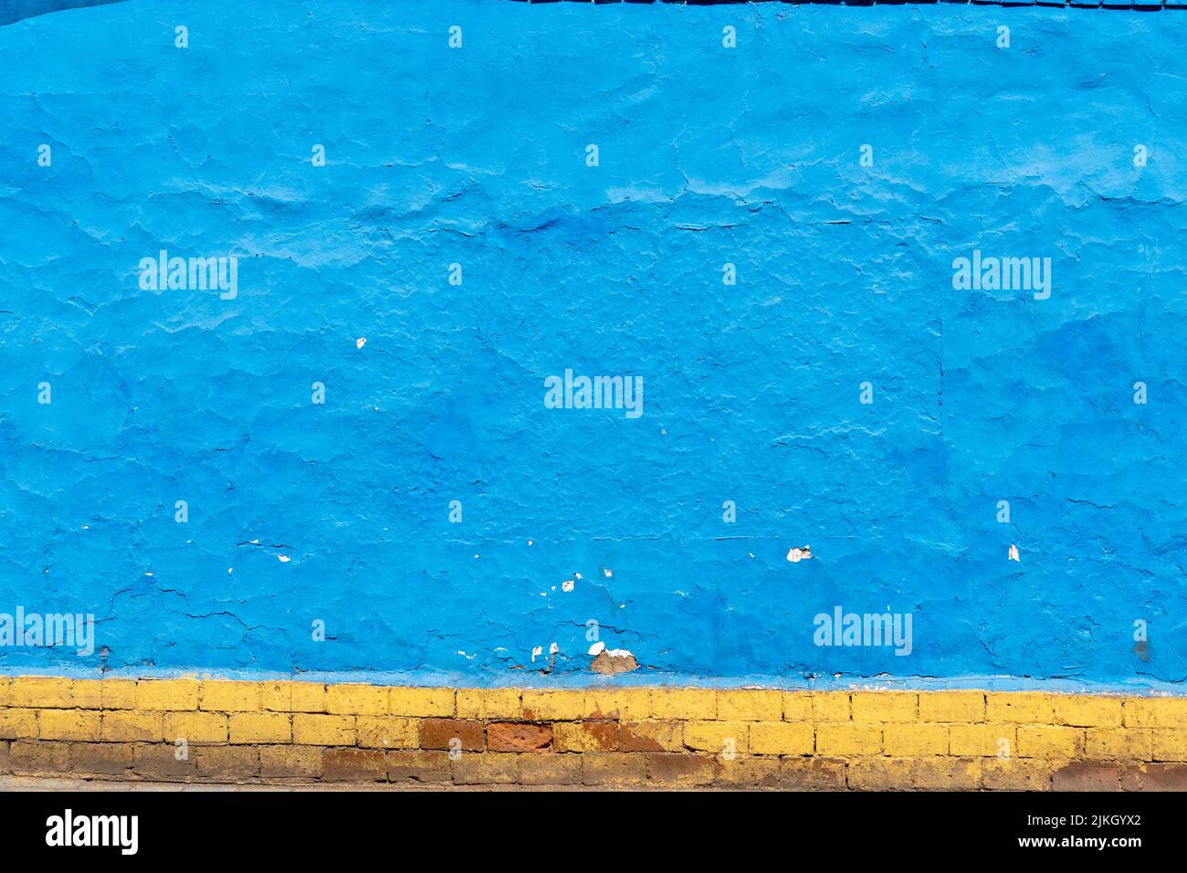 A cracked blue wall with brick from bellow Stock Photo - Alamy