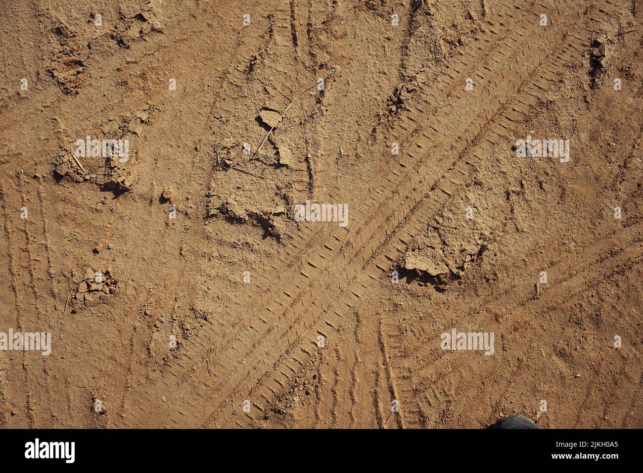 A dirt gravel road with tire tracks texture at the construction site ...