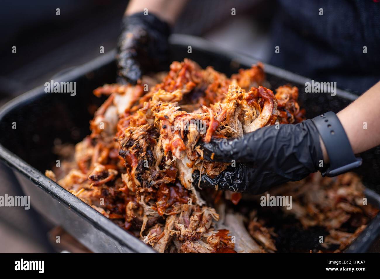 A chef's hands mixing meat with sauce in a black Stock Photo - Alamy