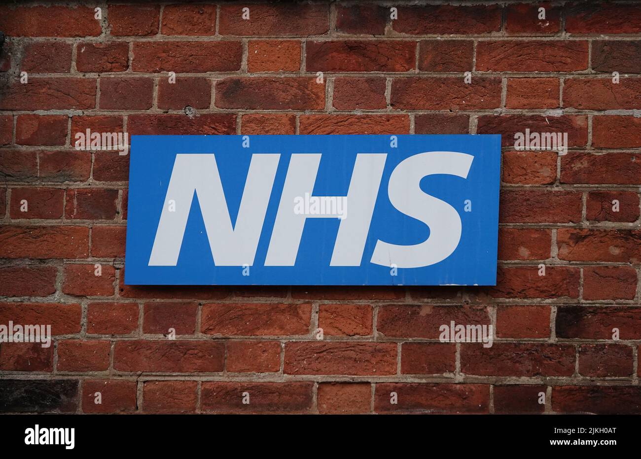 A blue and white NHS sign on a brick wall in York UK Stock Photo - Alamy