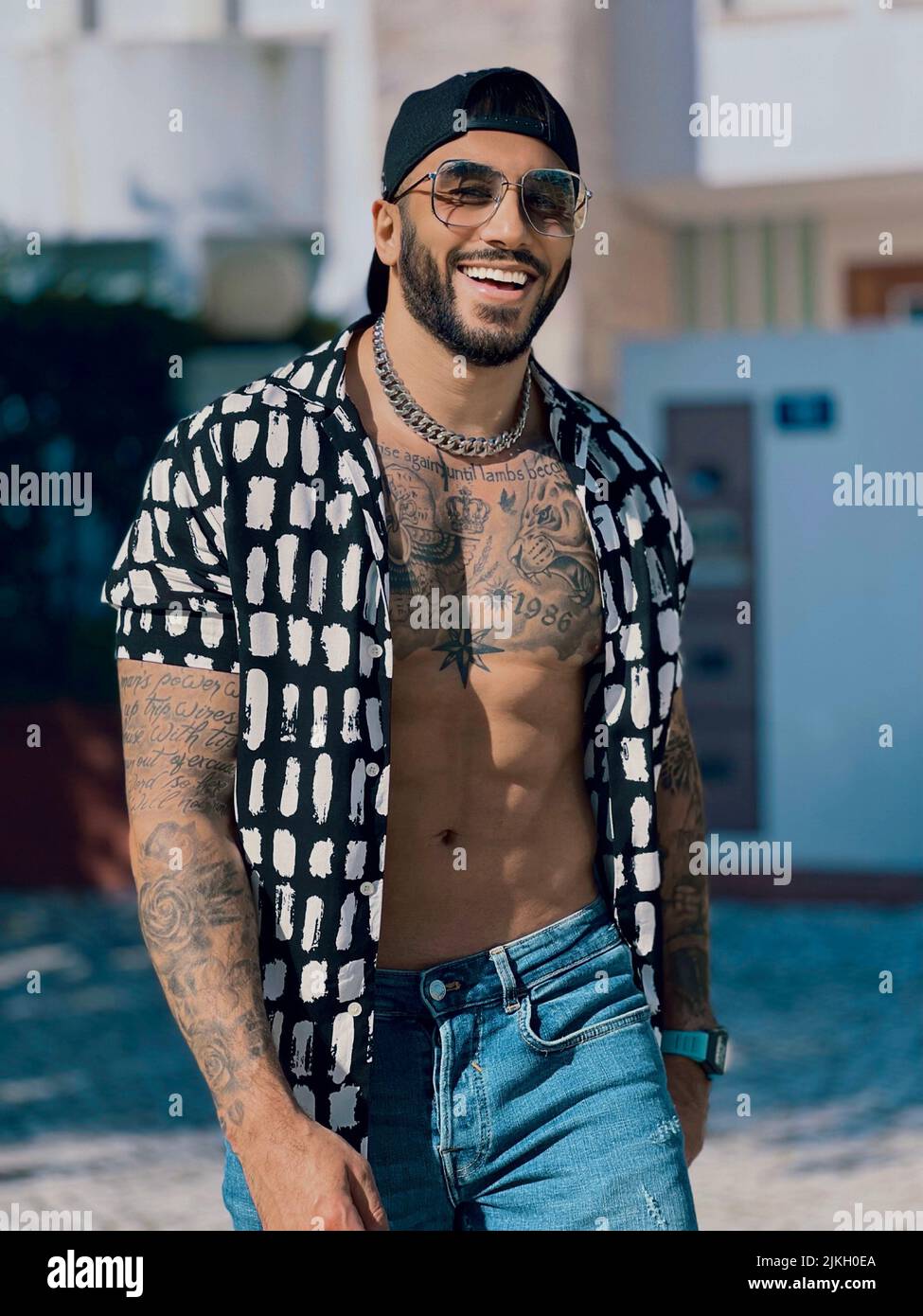 The vertical shot of a male adult tattooed model wearing sunglasses and ...