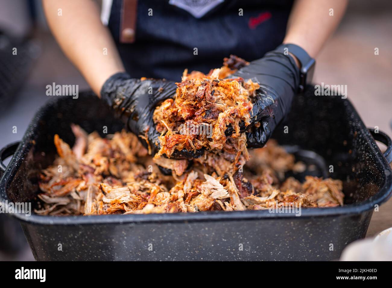A chef's hands mixing meat with sauce in a black Stock Photo - Alamy