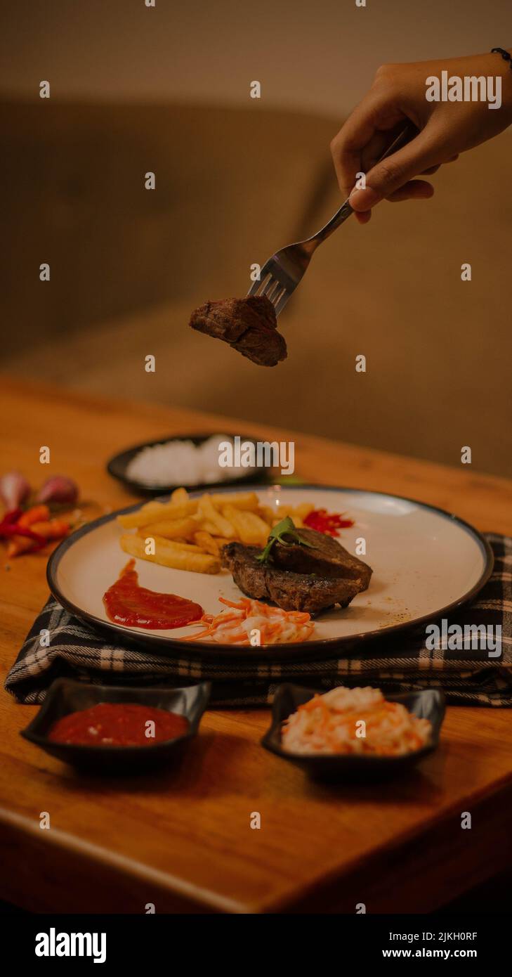 A woman eating delicious buffalo steak Stock Photo - Alamy