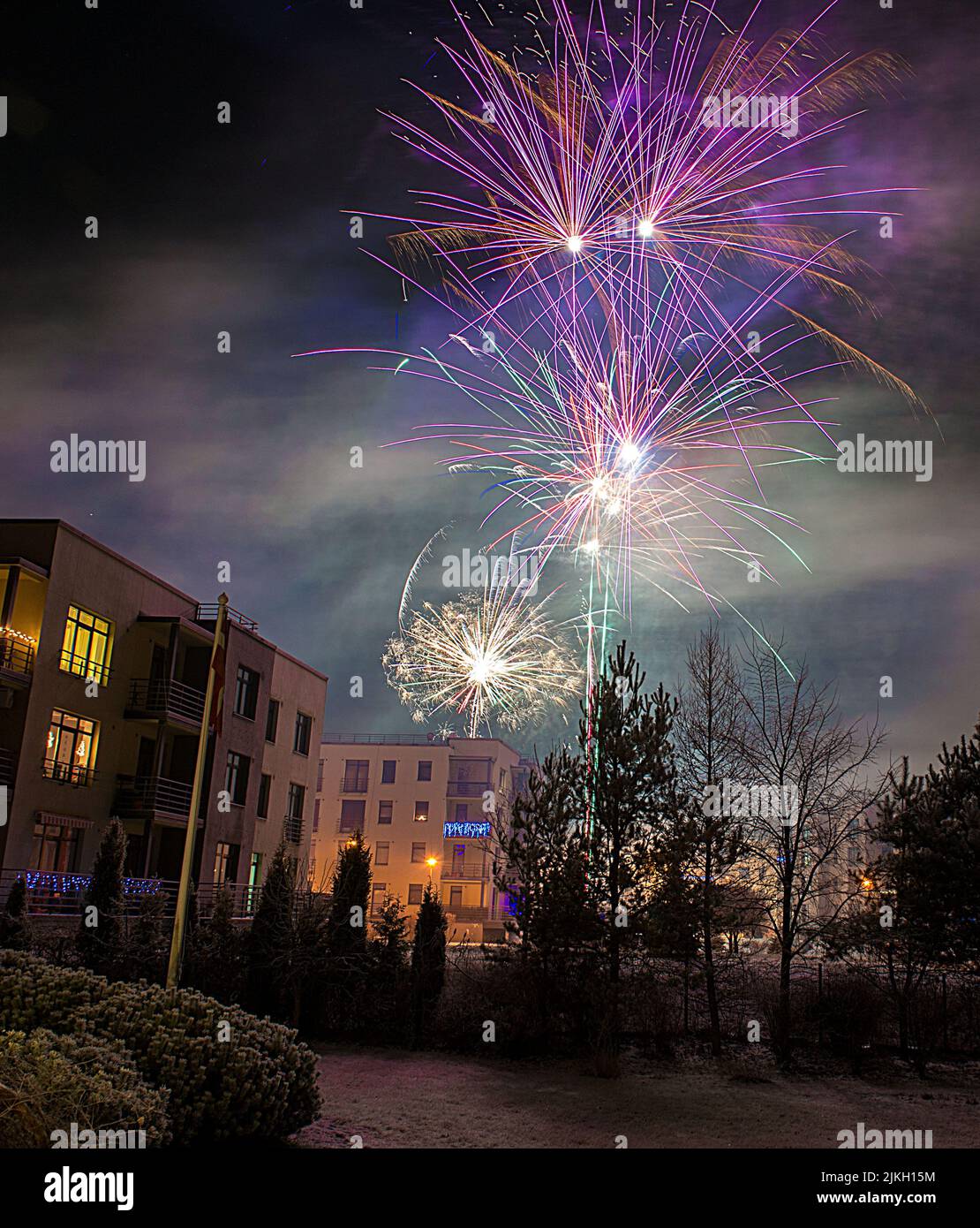 A vertical shot of colorful new year fireworks in a city with cold ...