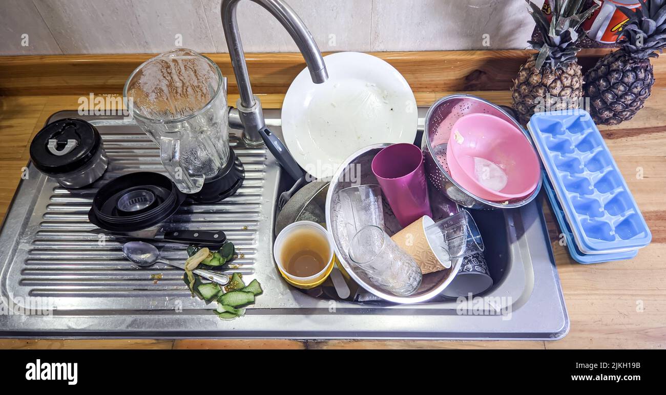 A pile of unwashed dirty dishes in the sink Stock Photo - Alamy