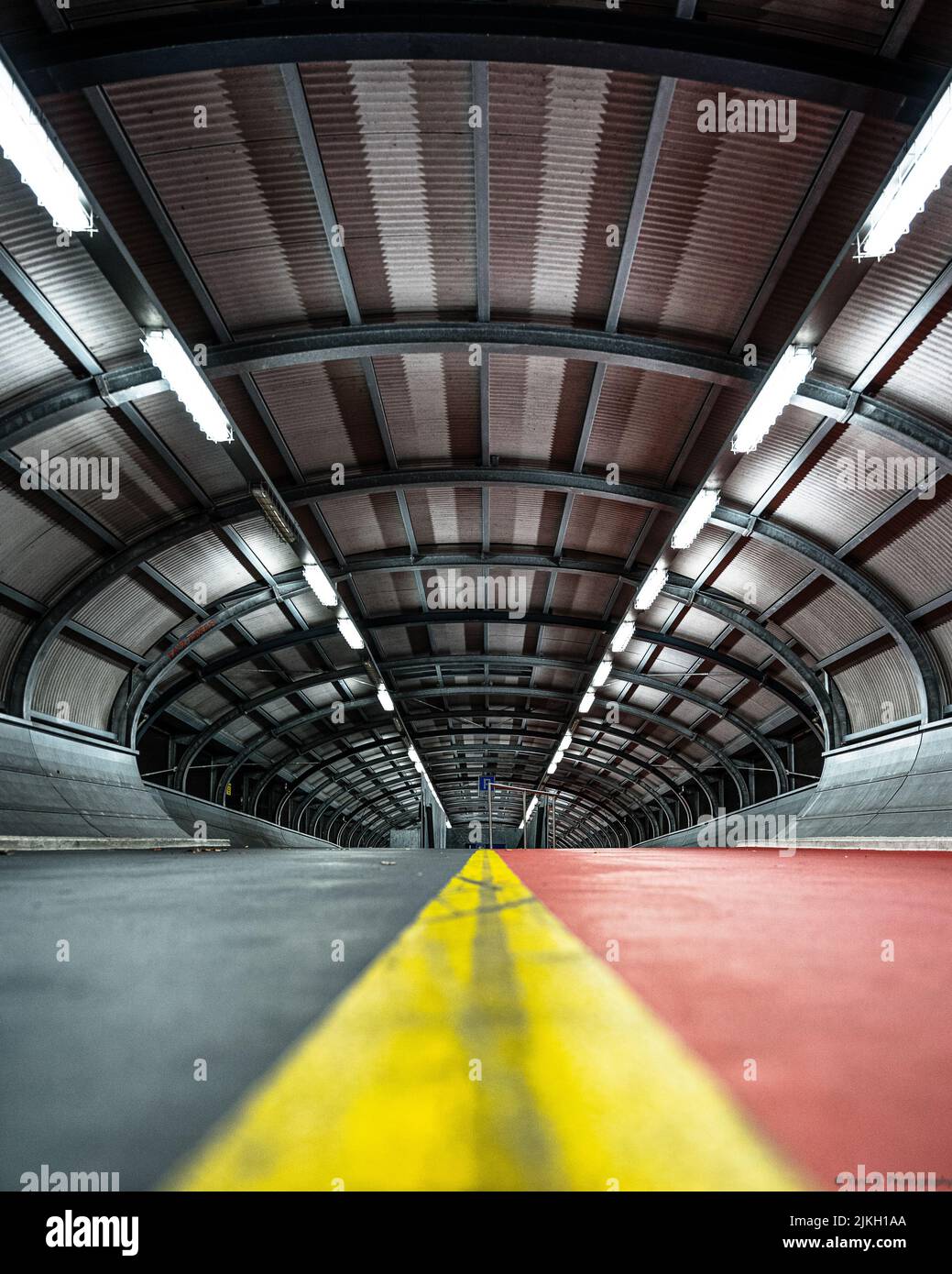 A vertical wide-angle shot of a tunnel with a red and yellow road in ...