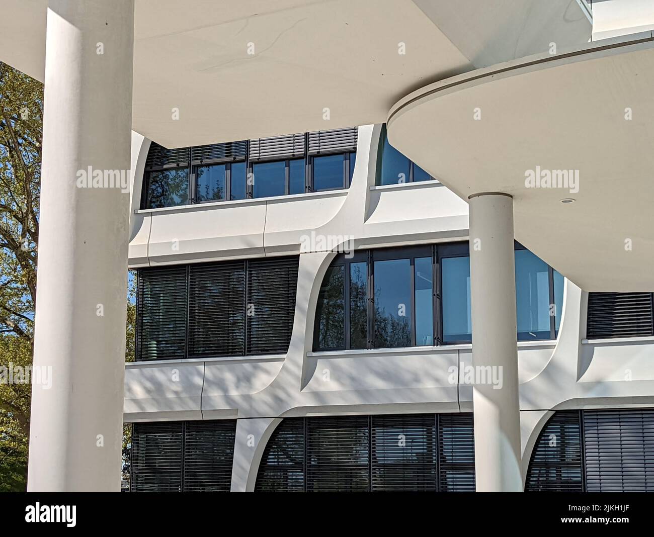 An exterior of a modern white office building with columns and large windows Stock Photo - Alamy