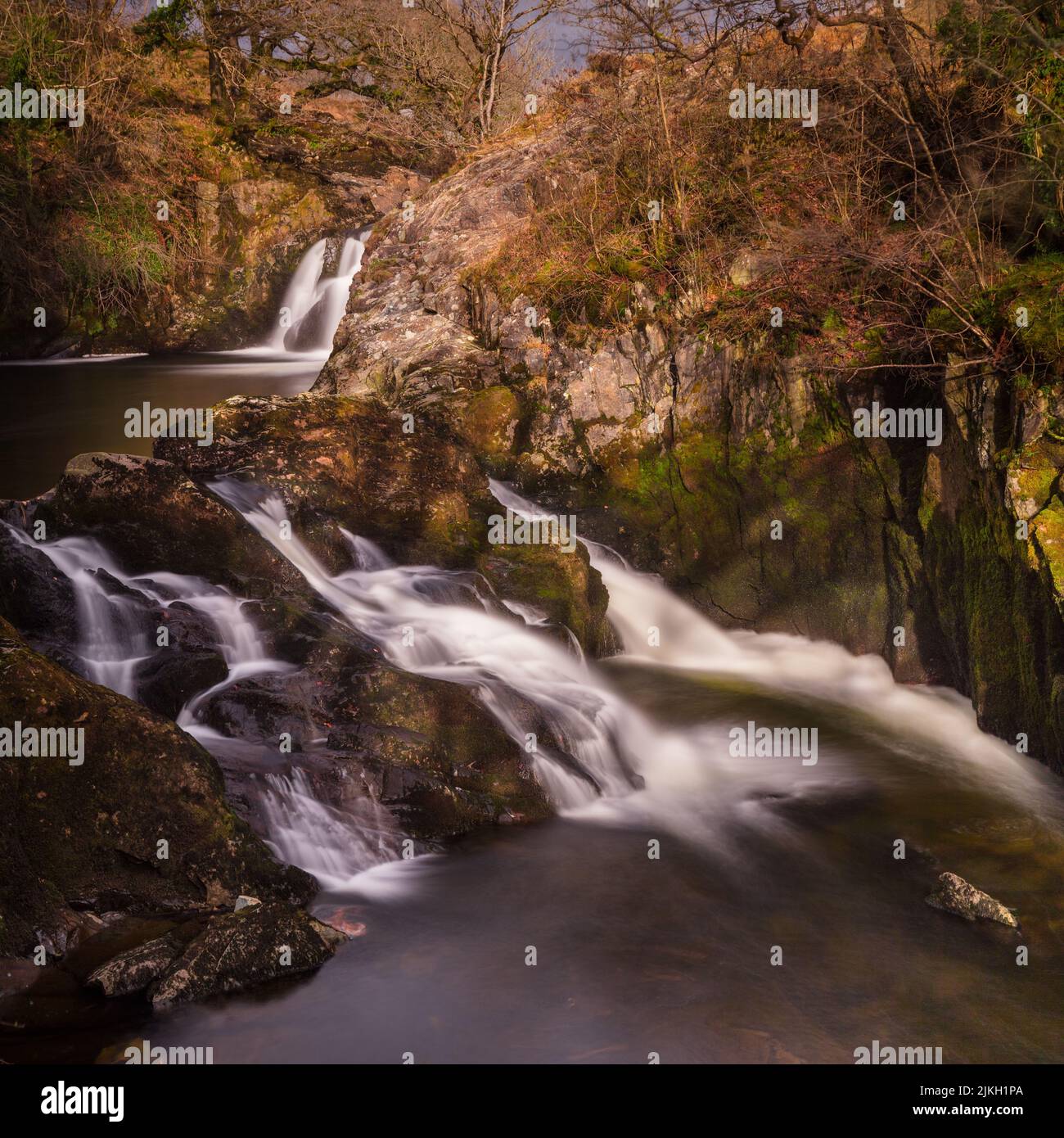 A long exposure shot of Beezley Falls surrounded by trees in Ingleton ...