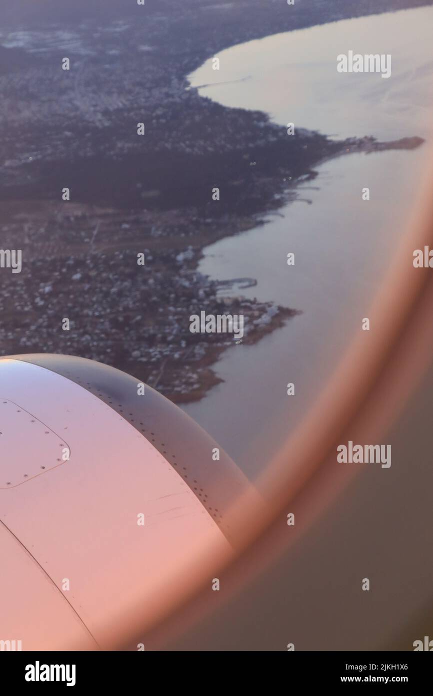 A vertical shot of the view of a city on the shore from an airplane ...