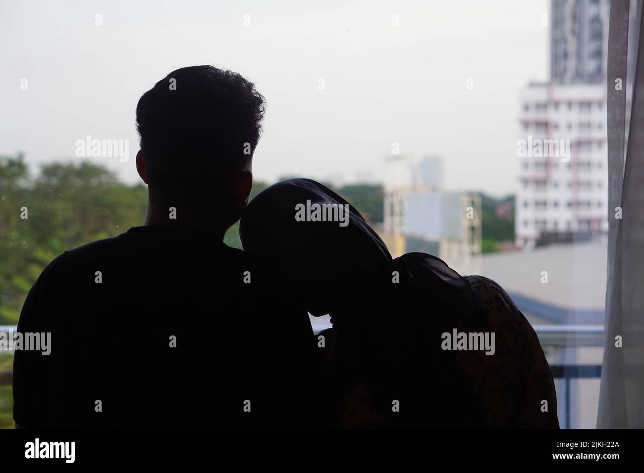 A silhouette of a cute couple sitting looking out the window Stock ...