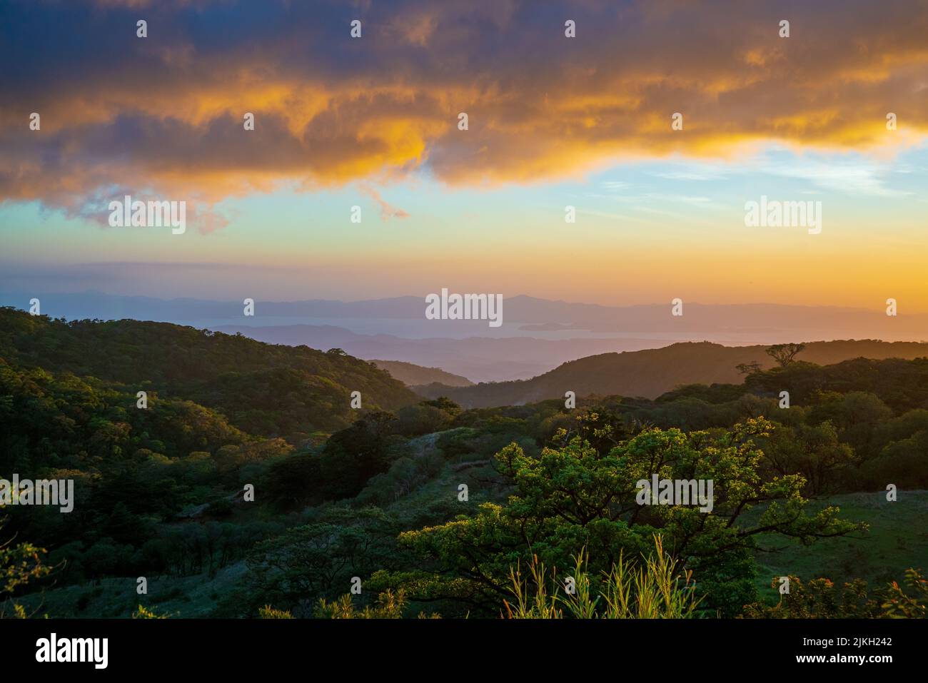 An aerial view of a golden bright sunset sky over rural fields and ...