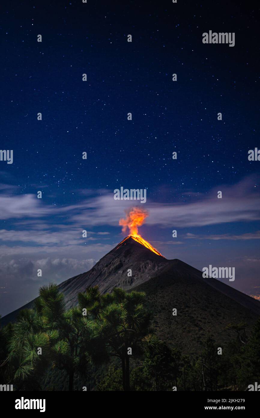 A vertical shot of fire coming out of the Fuego Volcano in Guatemala ...