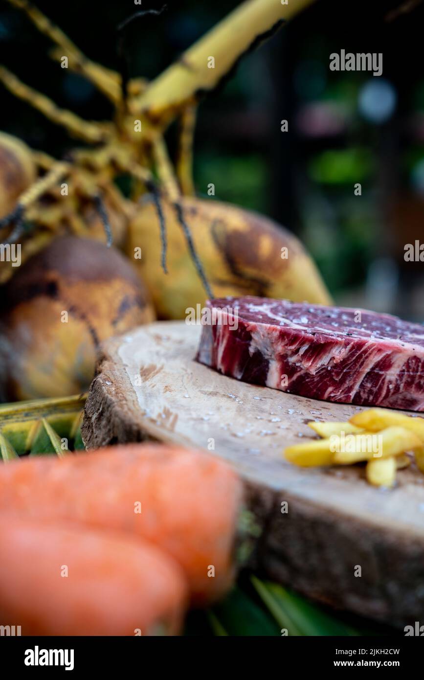 A vertical shot of a raw slice of red steak on a log board Stock Photo ...