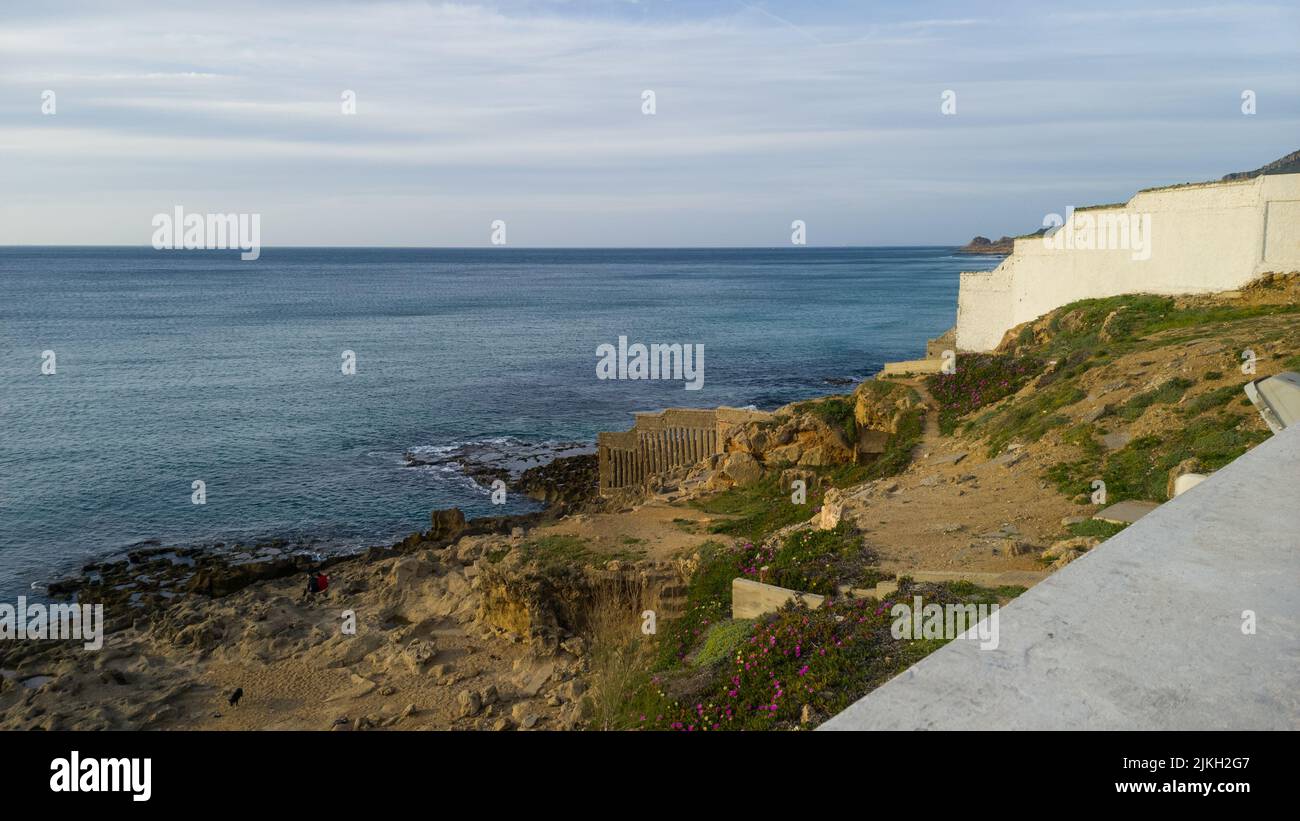 A historic stone wall on a cliff near the water in Tangier, Morocco ...