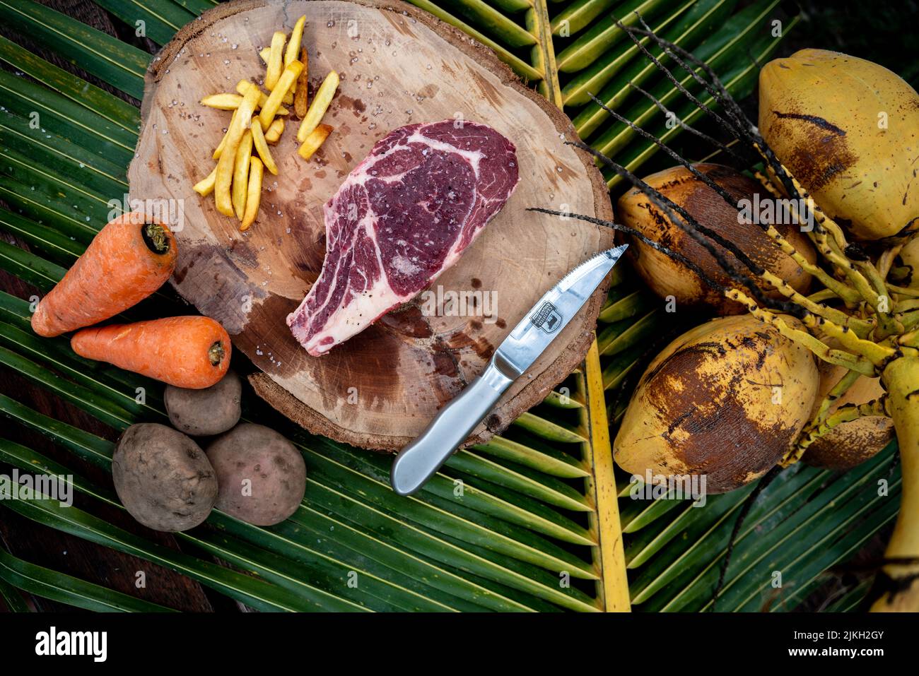 A top view of a raw steak on a wooden log board with a knife, french ...