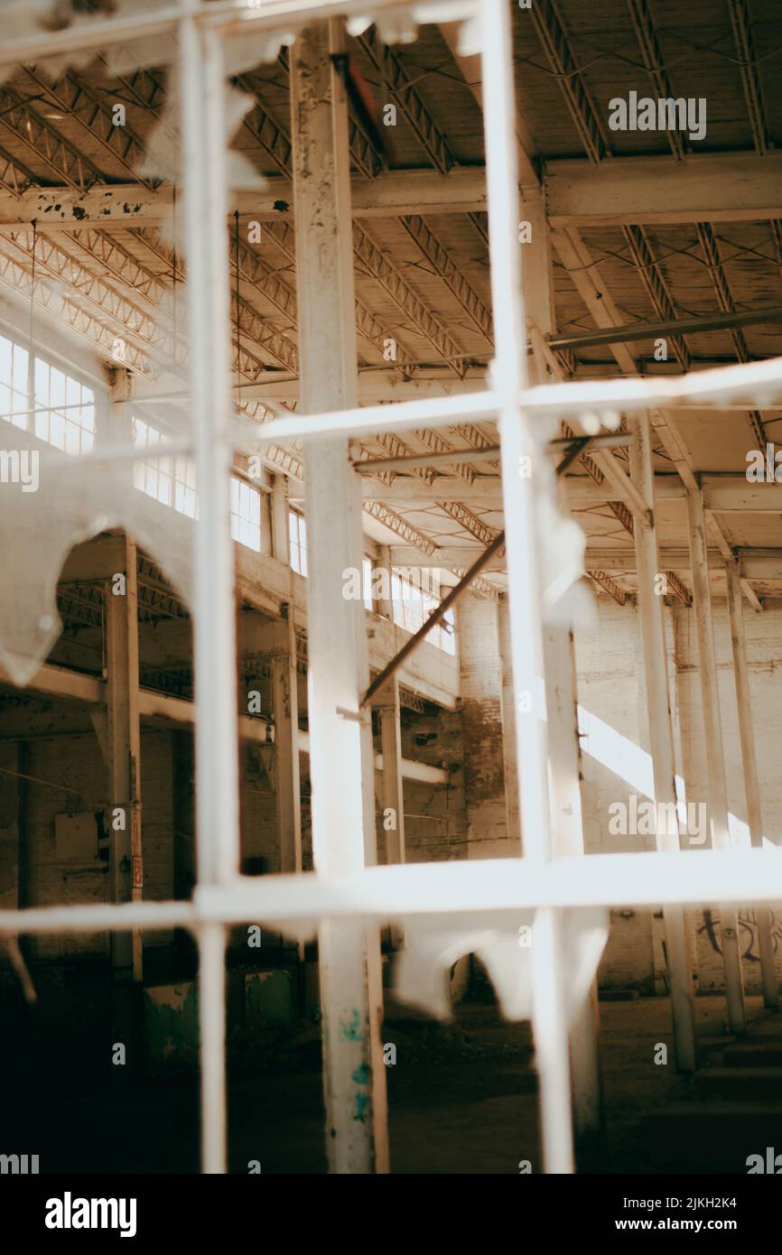 A vertical shot of the view through a broken window of an abandoned ...