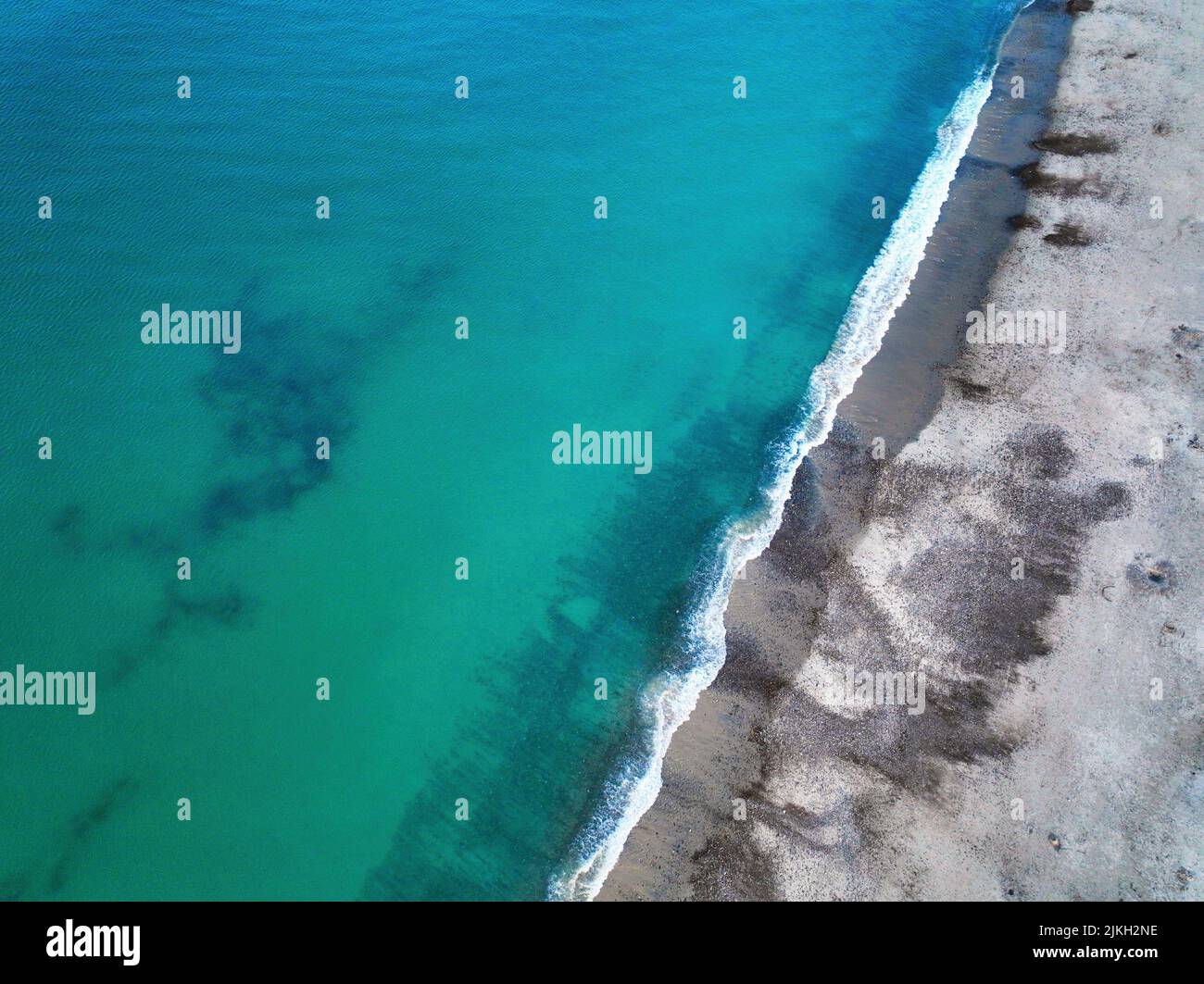 An aerial top view of blue ocean waves washing a sandy beach Stock ...