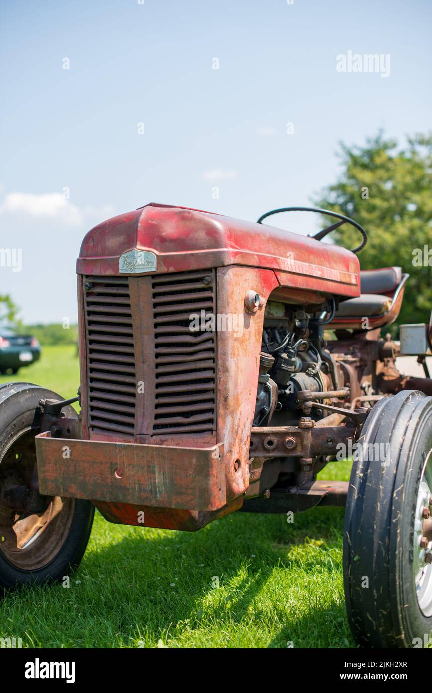 A vertical shot of a rusty old red tractor at a farm in Ontario Stock ...