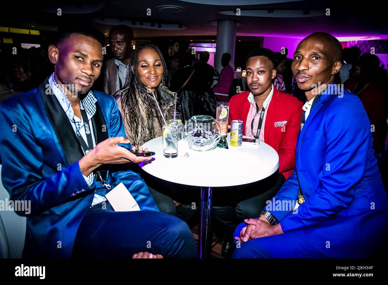 A group of African American people sitting around a table with drinks ...