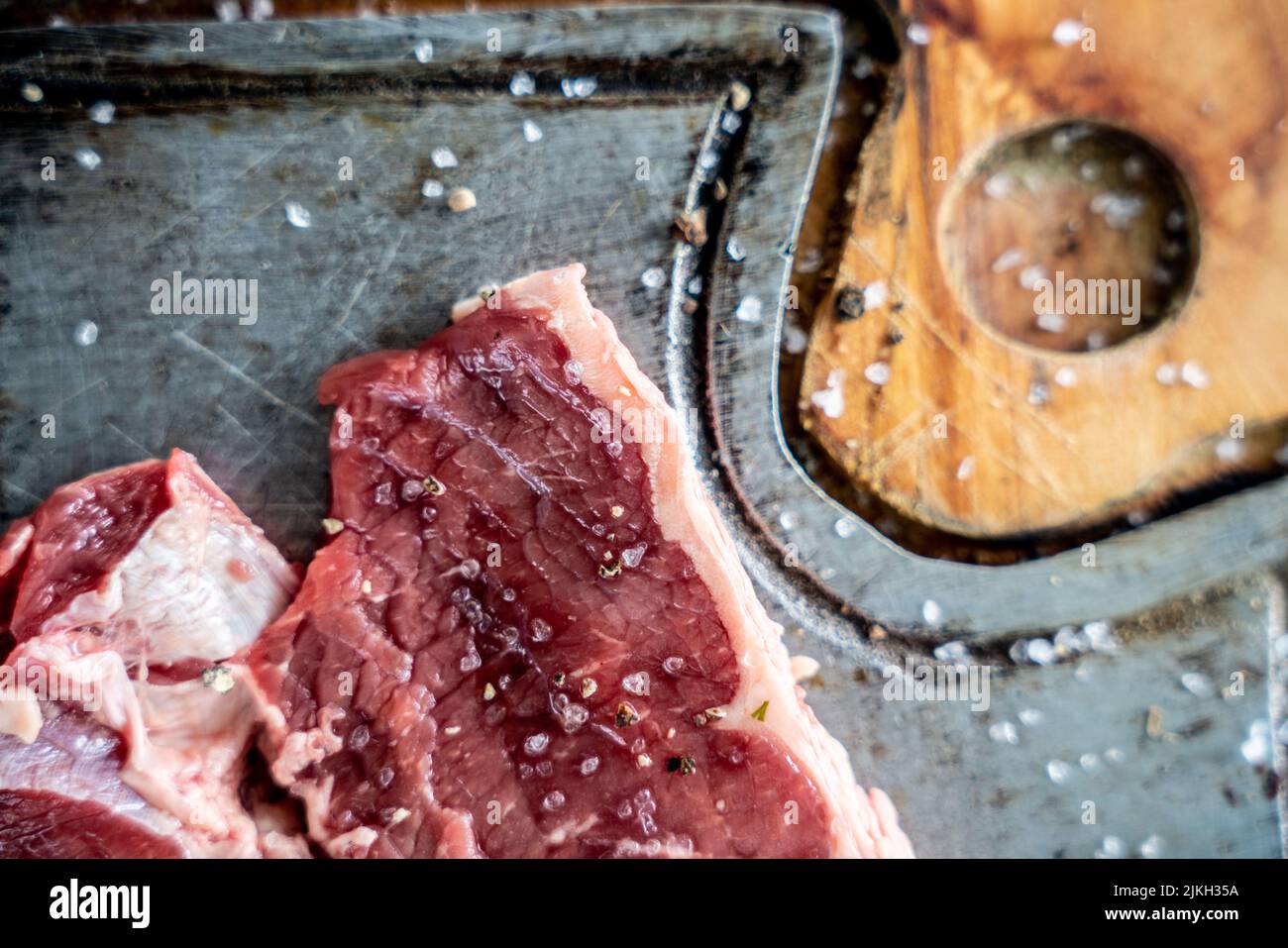 A top view of a seasoned raw red steak slice on a cooking board Stock ...