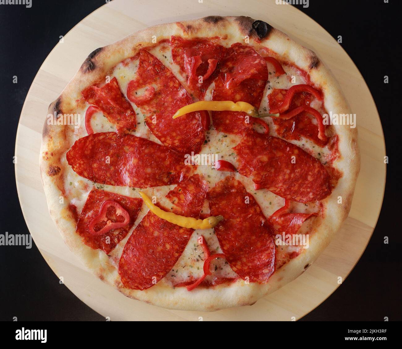 A top view of a pizza with salami, peppers and cheese toppings Stock ...