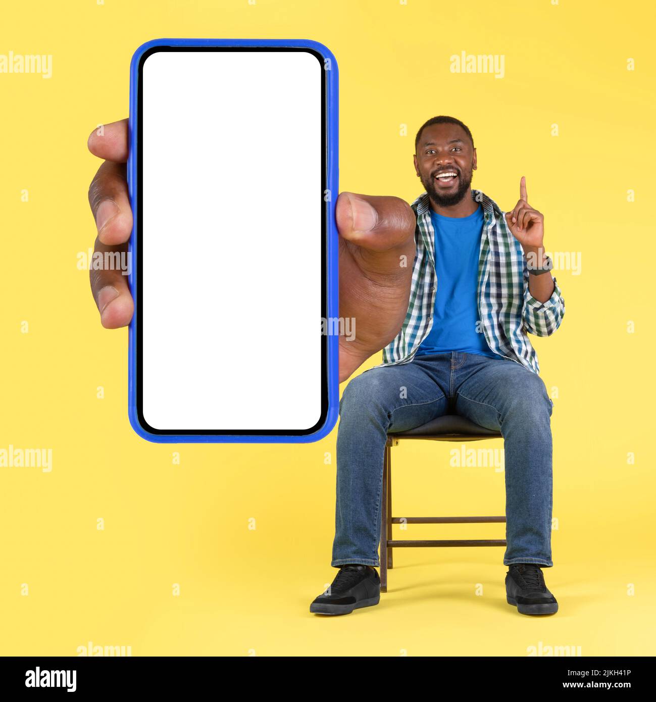African American Male Showing Huge Cellphone Sitting On Yellow ...