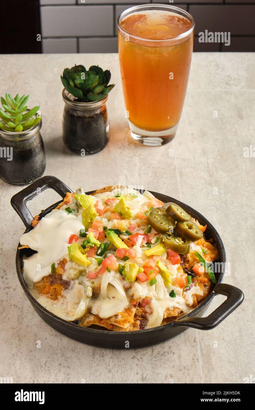 A vertical closeup shot of Mexican nachos with toppings Stock Photo - Alamy