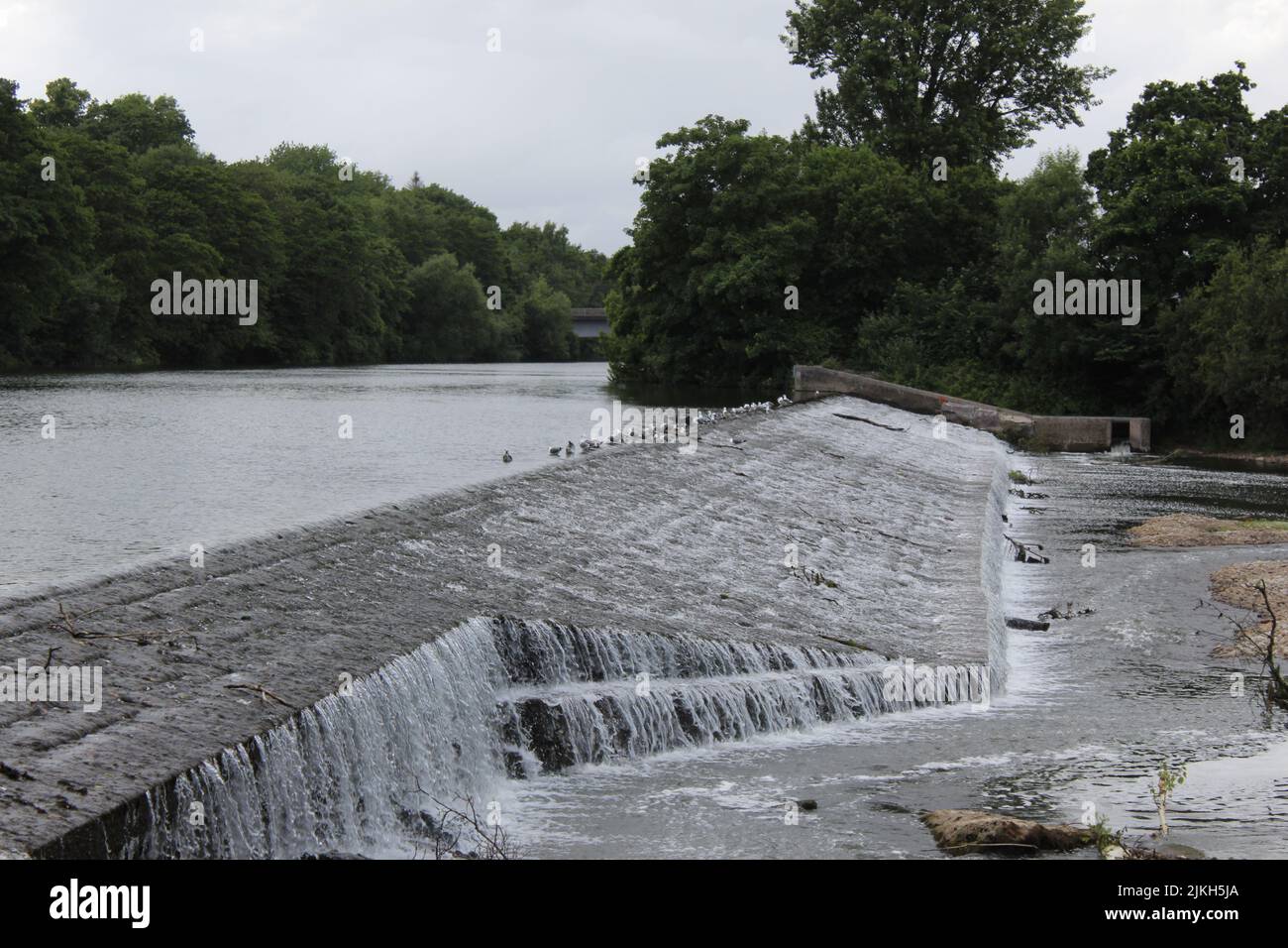 A view of water streaming on a river dam Stock Photo - Alamy