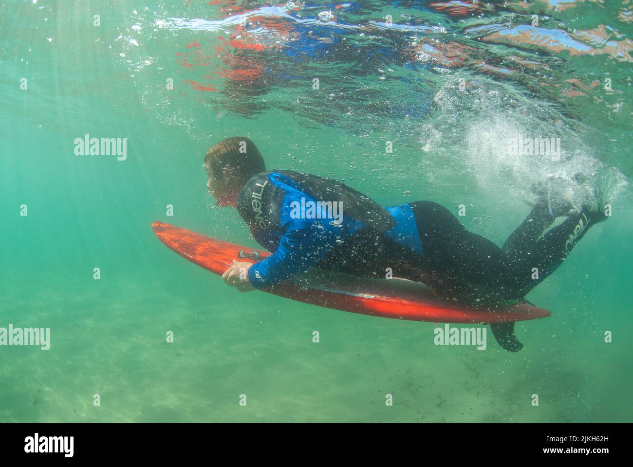 Surfer duck diving a wave when paddling out, West Dale, Wales, UK Stock ...