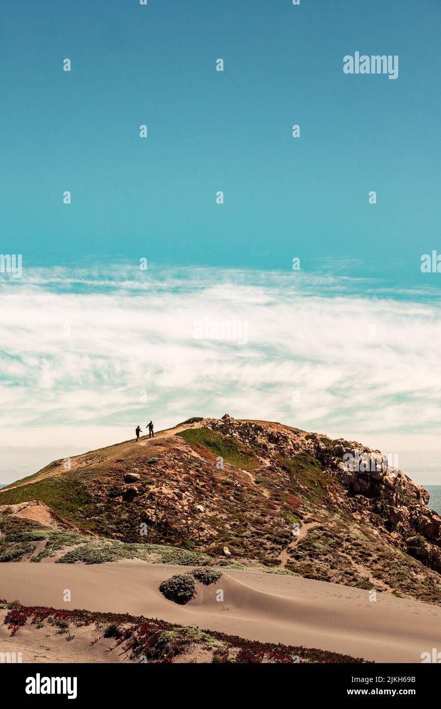 A vertical view of a landscape with mountain and cloudy sky in the ...