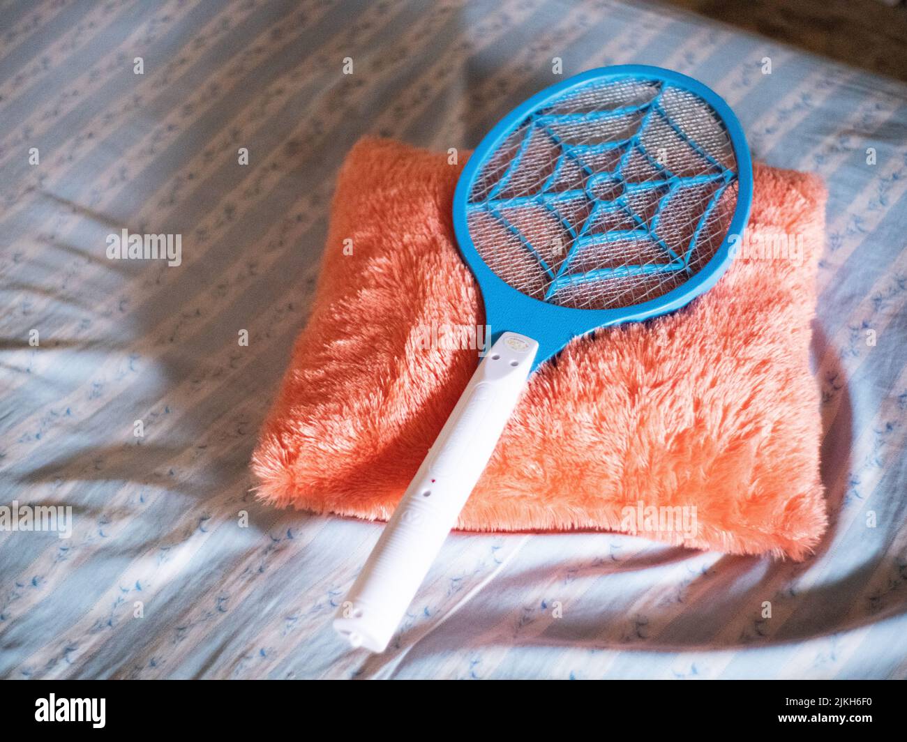 A blue mosquito racket on a fluffy pillow Stock Photo - Alamy