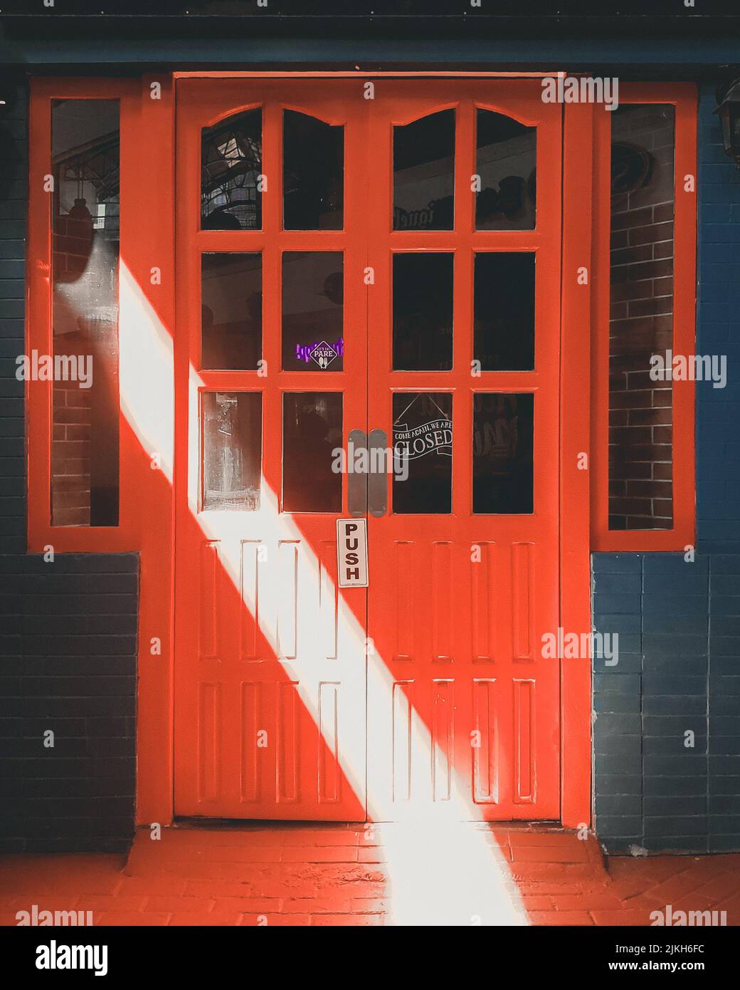 A entrance bright red door in BGC Taguig. A beam of light falls on the ...