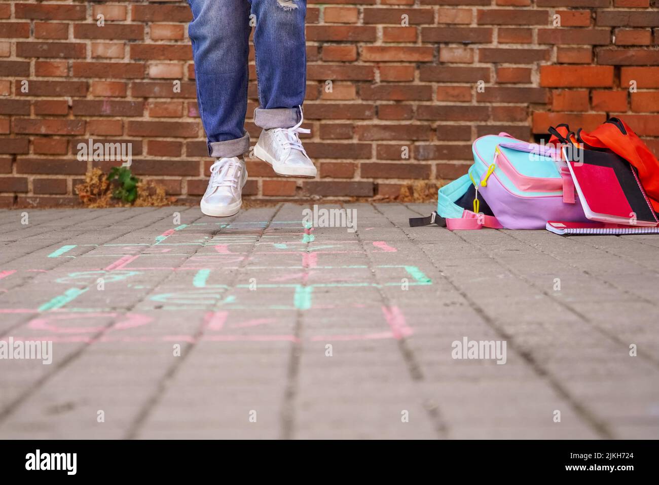 girl playing hopscotch on school playground. back to school concept ...
