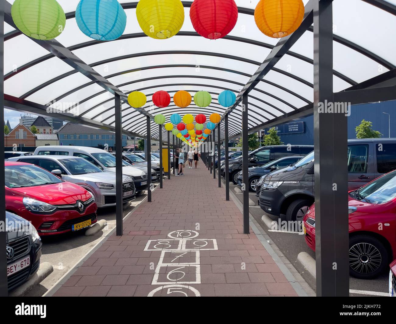 Few cars parked on the sides of a decorated pathway in a parking lot ...