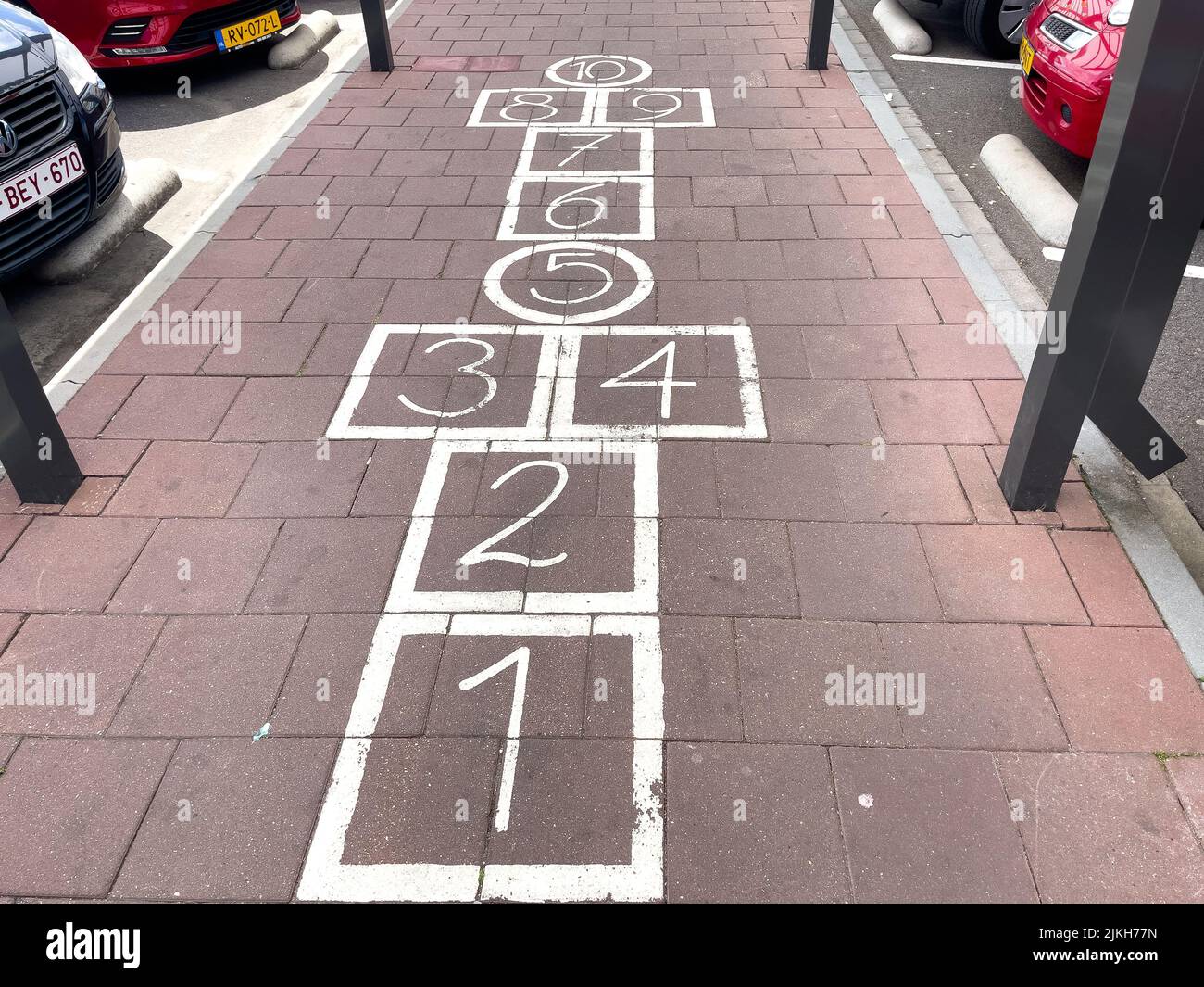 Few cars parked on the sides of a decorated pathway in a parking lot ...