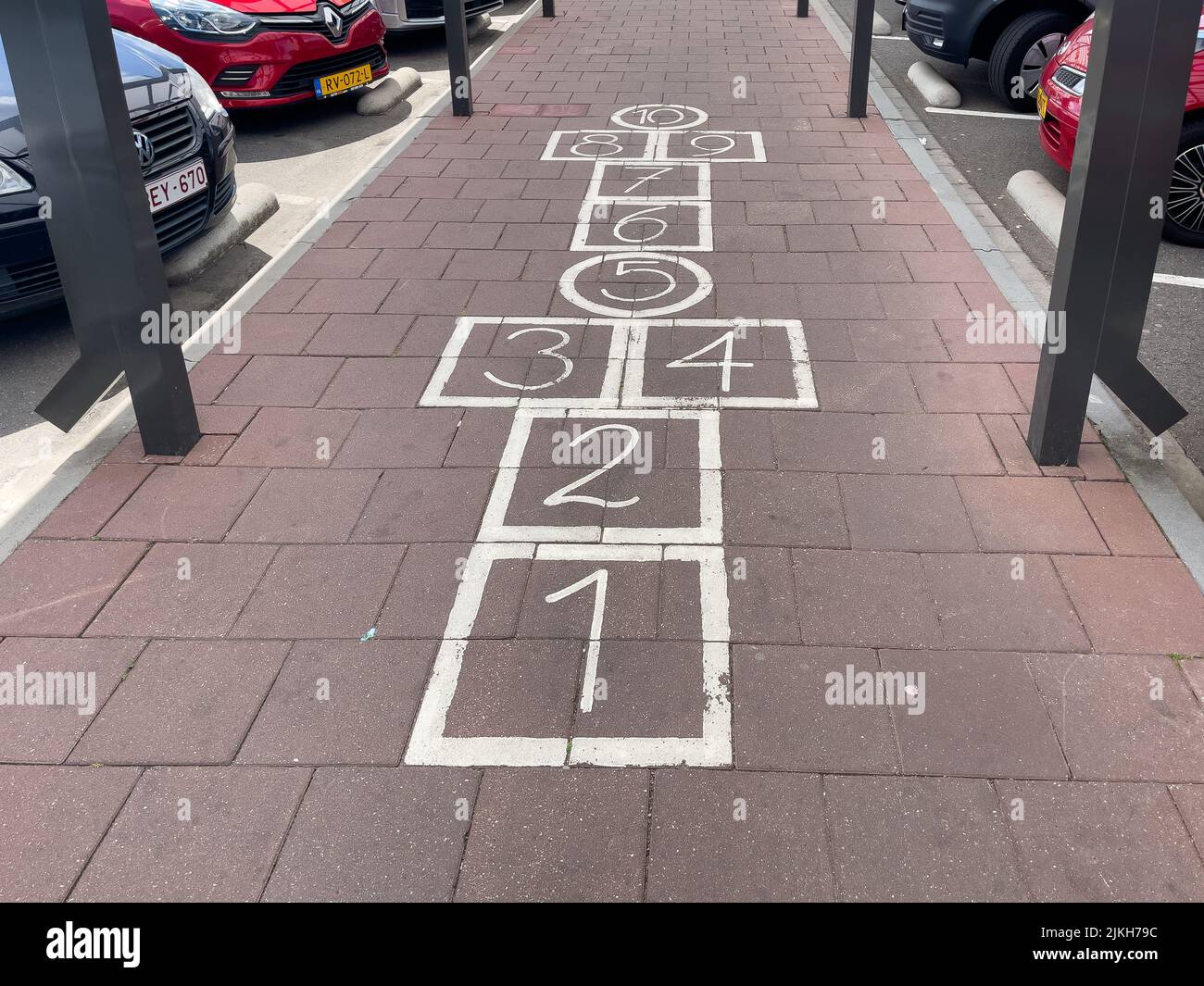 Few cars parked on the sides of a decorated pathway in a parking lot ...