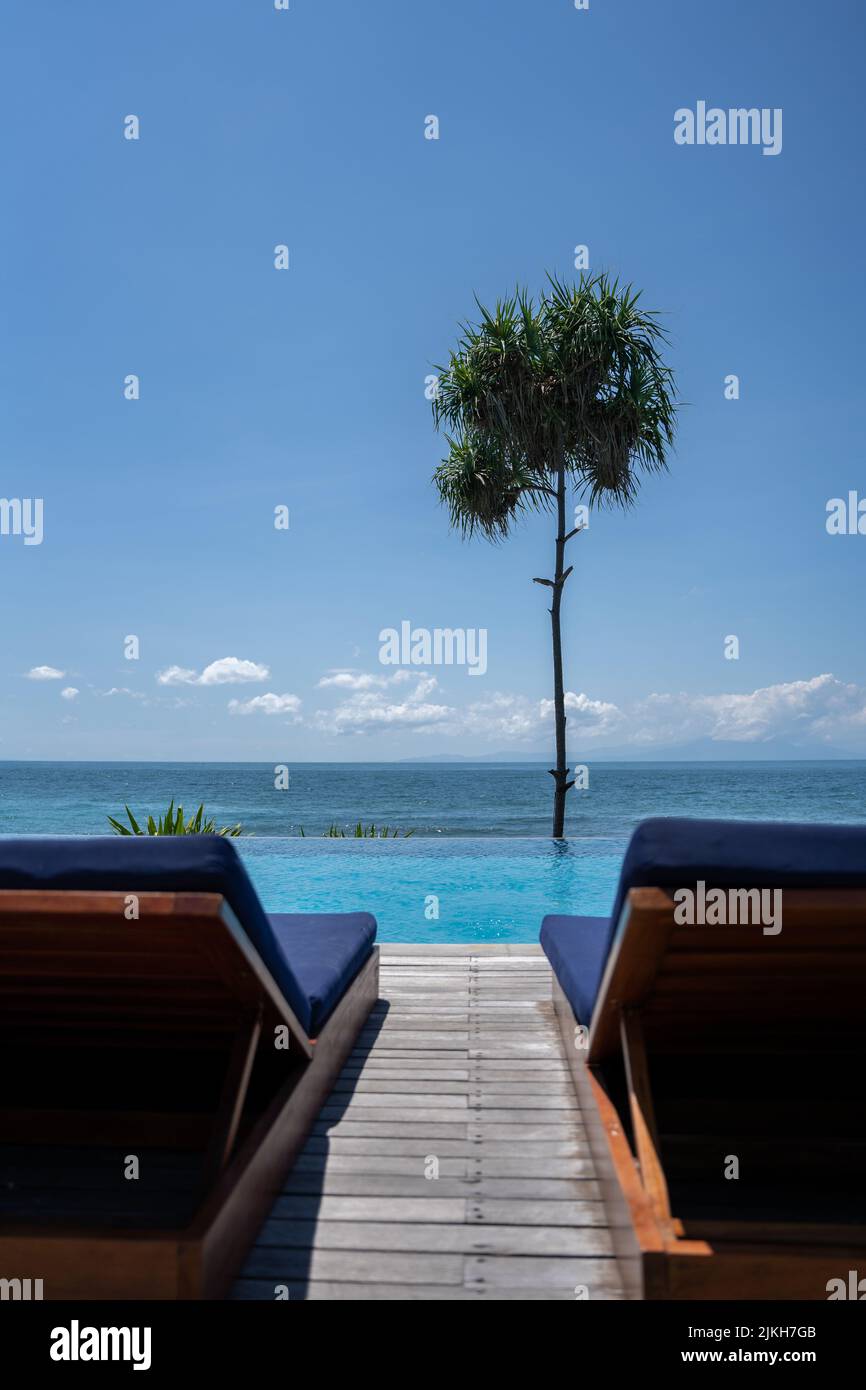 A vertical shot of an infinity pool with sunbeds Stock Photo - Alamy