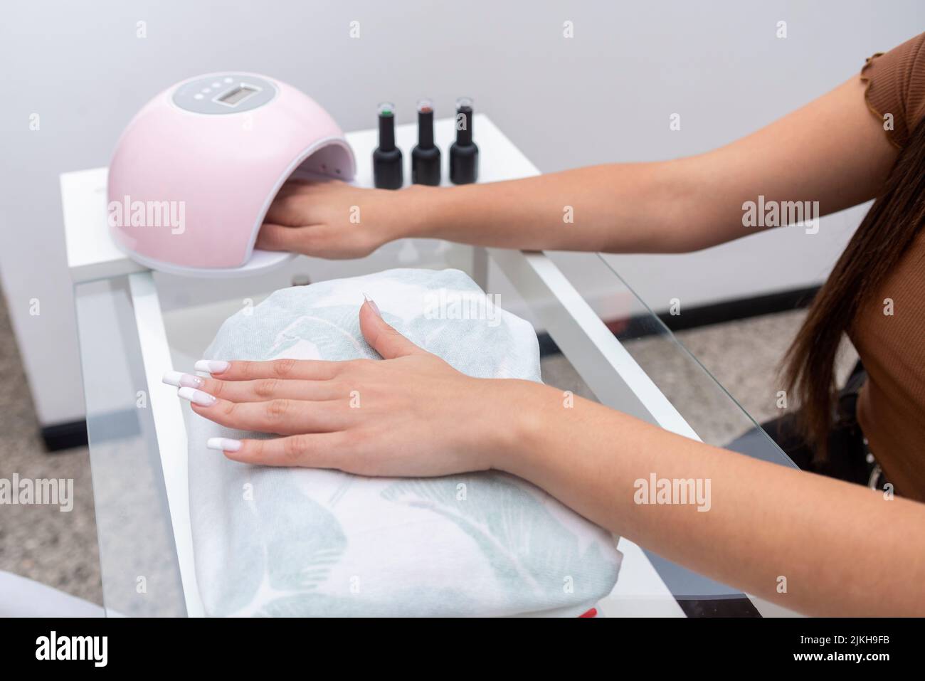 A woman in beauty center performing a nail service and beautification ...