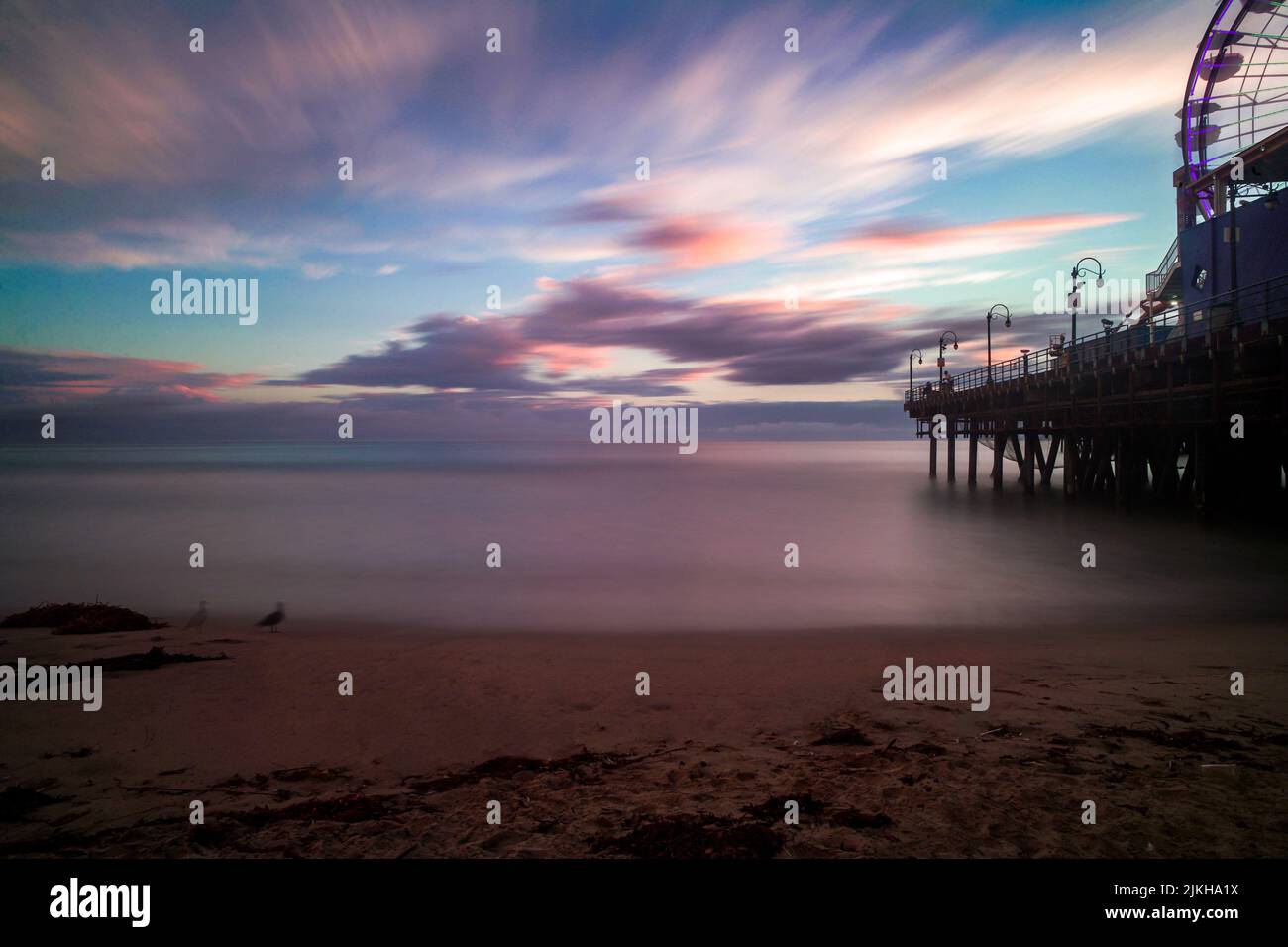 A bright purple pink sunset sky over Santa Monica pier in Los Angeles ...